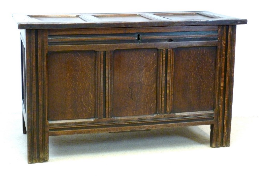 An 18th century oak panelled chest of three panels to the front and ...